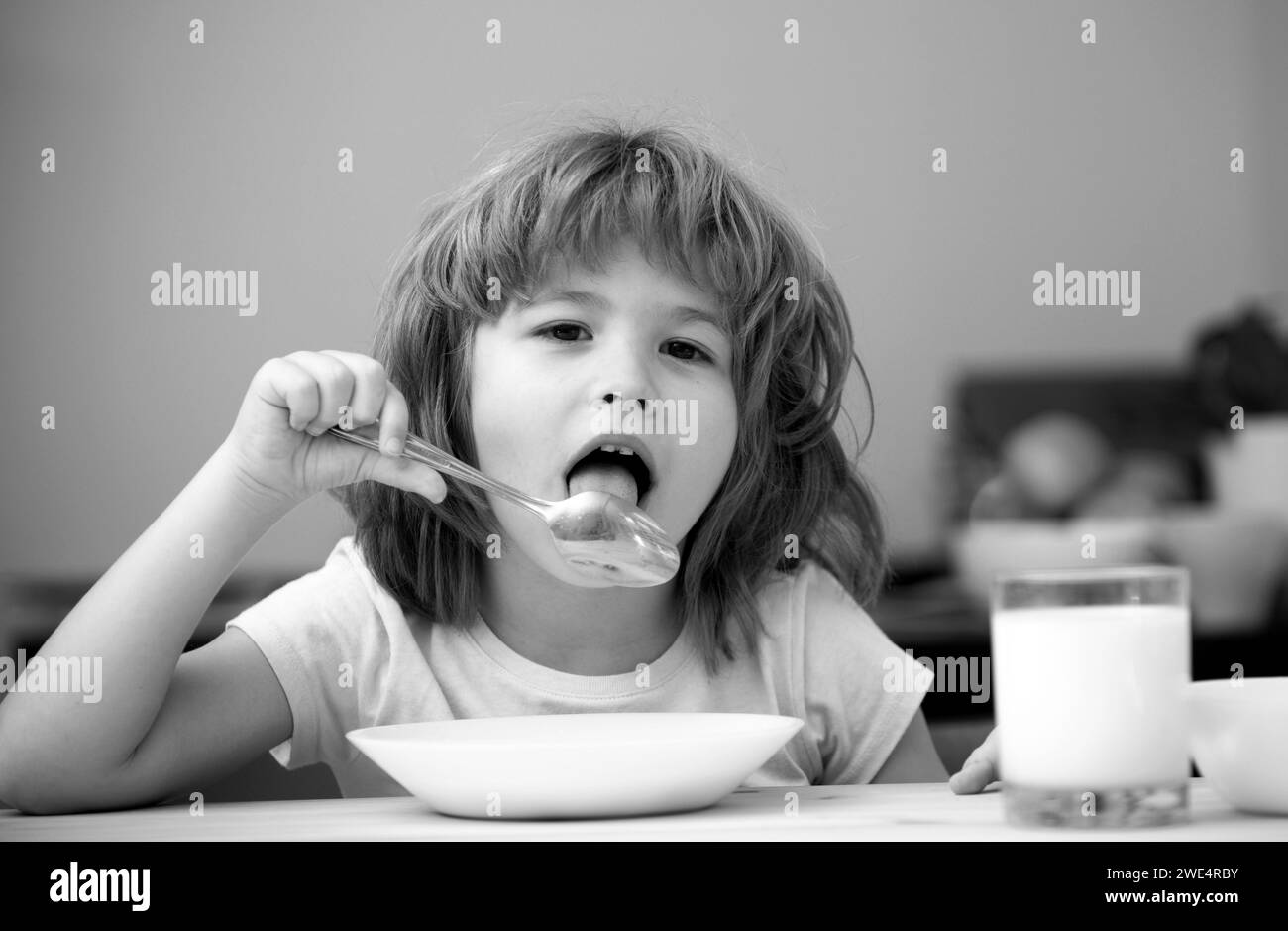 Portrait of cute child eating soup meal or breakfast having lunch by ...