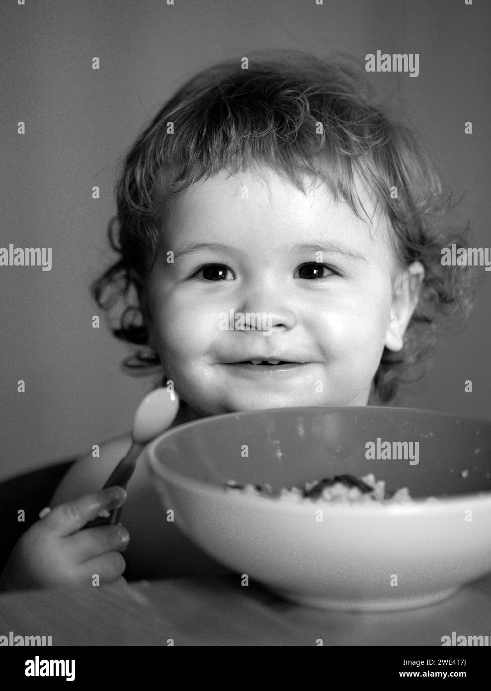 Portrait of cute Caucasian child kid with spoon. Hungry messy baby with ...