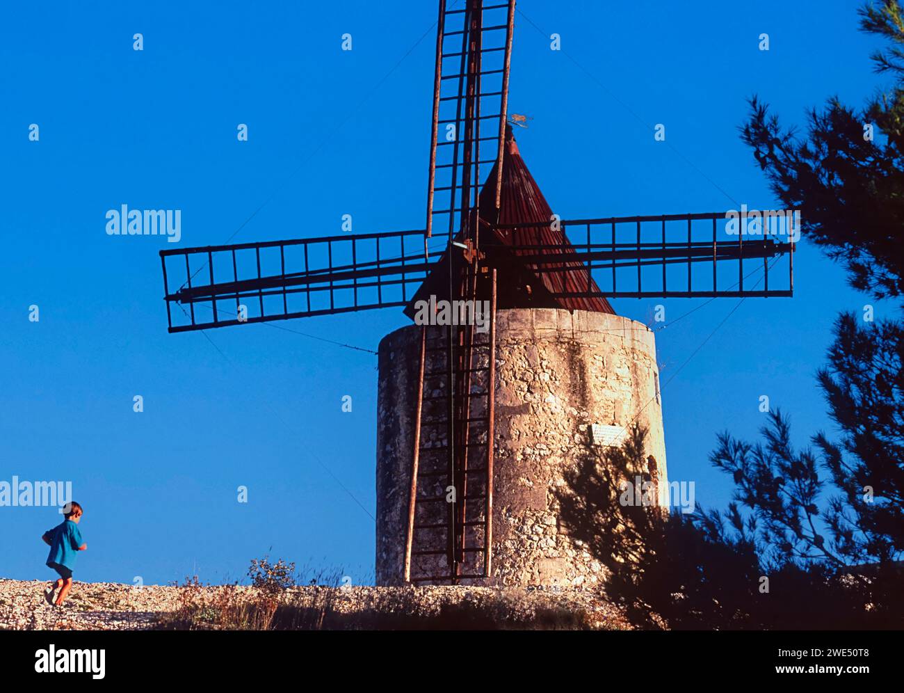 Old traditional stone windmill in Provence France and a running boy in ...