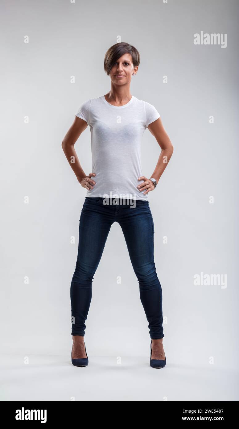 Confident woman stands firmly, her casual yet stylish attire ...