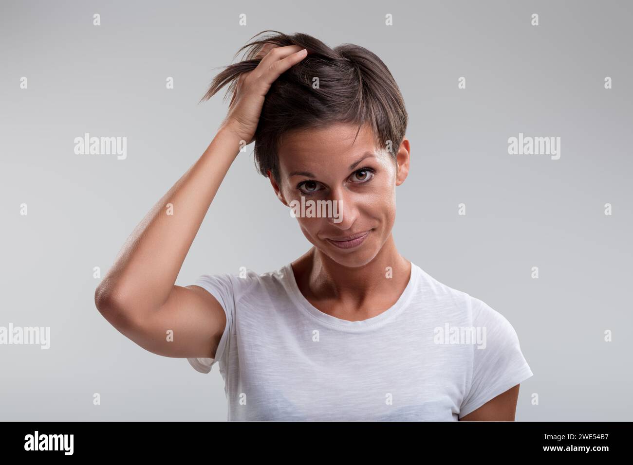 Her tentative touch on her head and coy smile reveal a readiness tinged ...