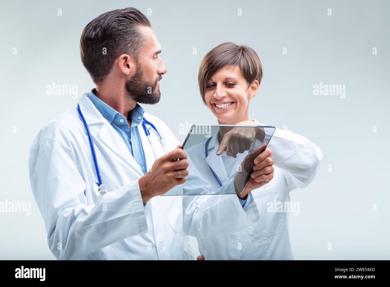 Medical team examines patient data on a transparent device, showcasing ...