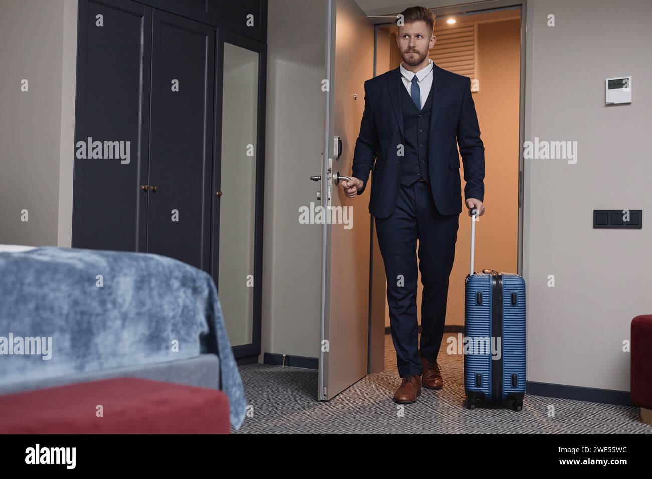 Full length portrait of successful young businessman entering hotel ...