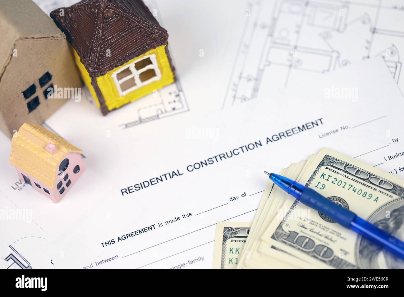 Residential construction agreement ready to sign with small toy houses ...