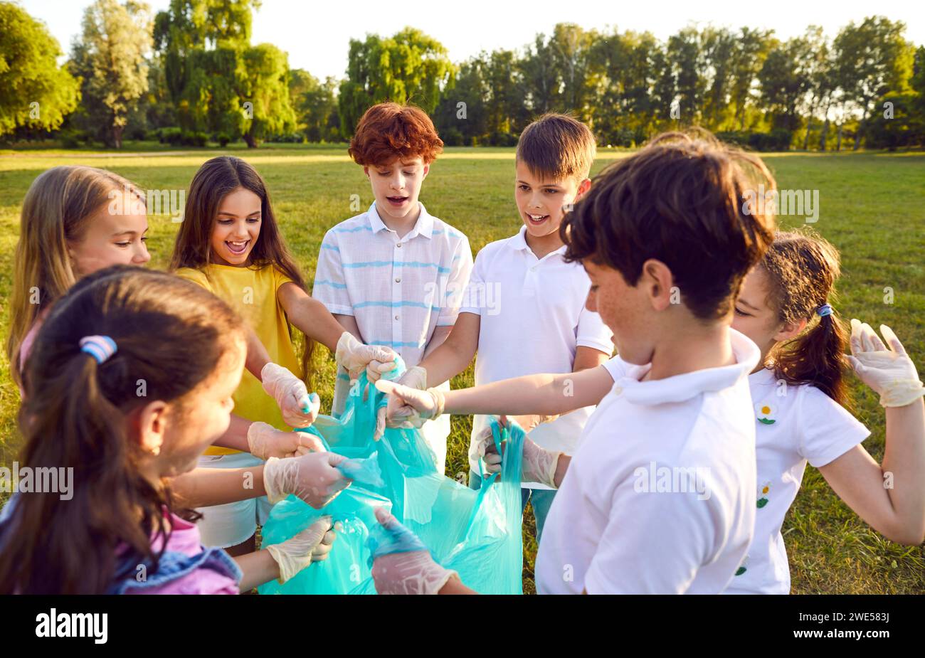 Group of a young volunteers children standing with garbage bags ...
