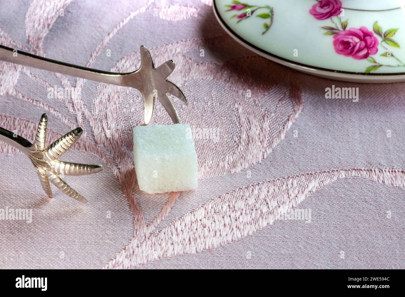 Sterling silver tongs are used in a formal afternoon tea with sugar ...