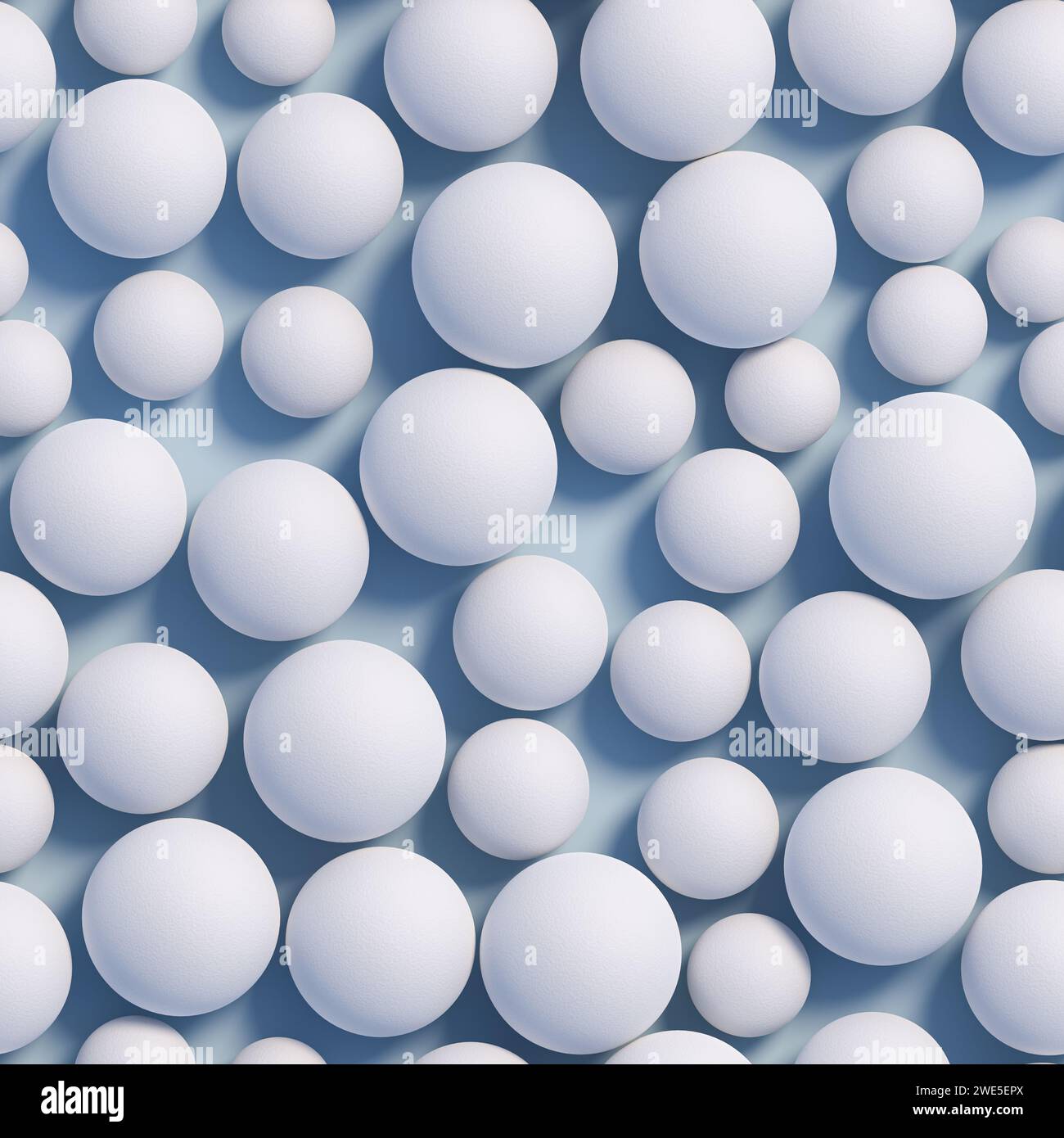 White Spheres in different sizes with a rough surface on a blue plane ...