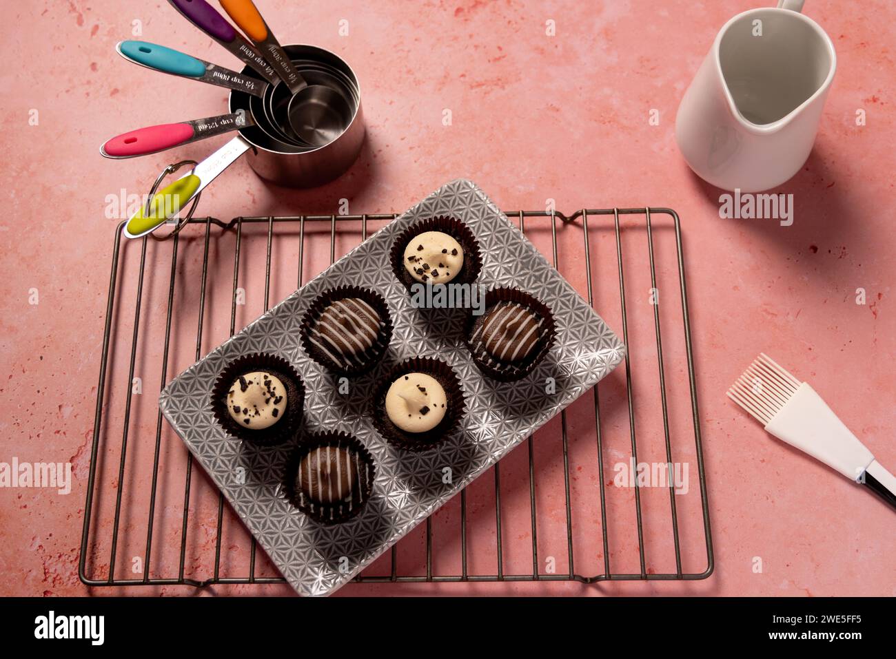 mini white and dark chocolate cupcakes with measuring cups and brush ...