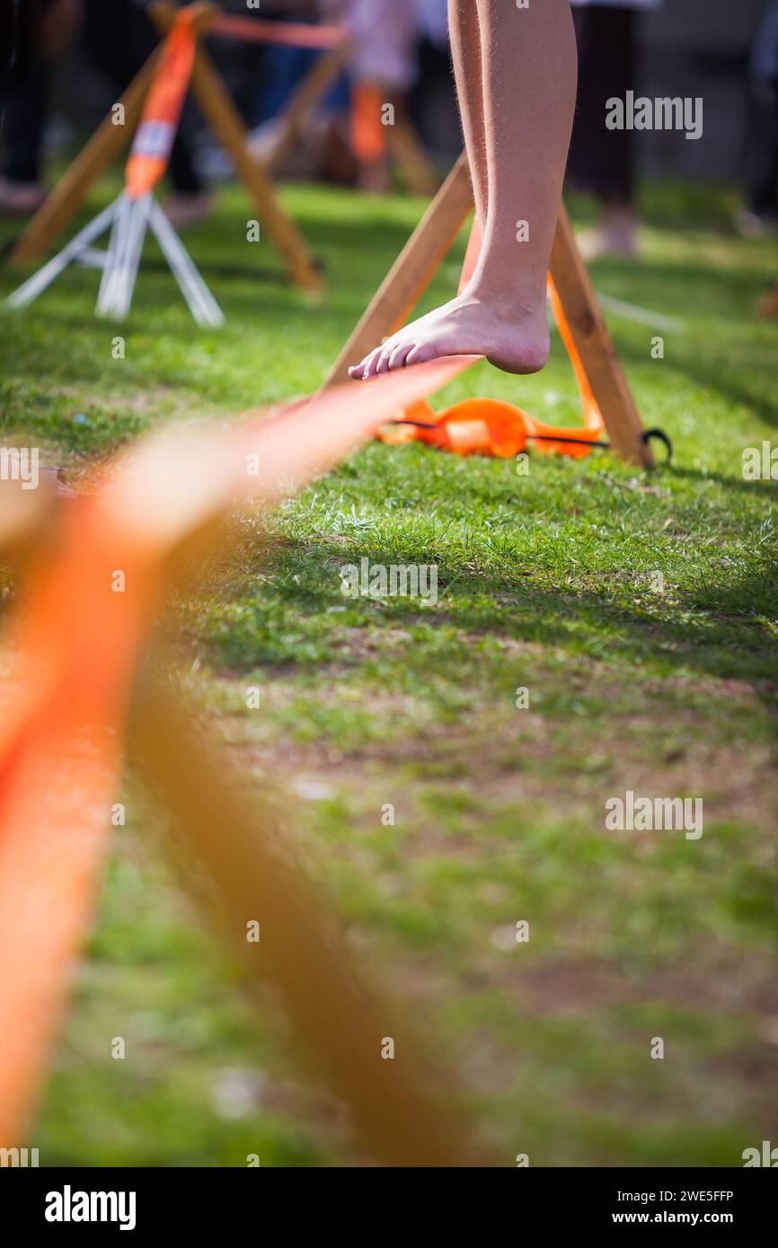 Slacklining on a patch of grass. Bare feet and legs visible. Balance ...