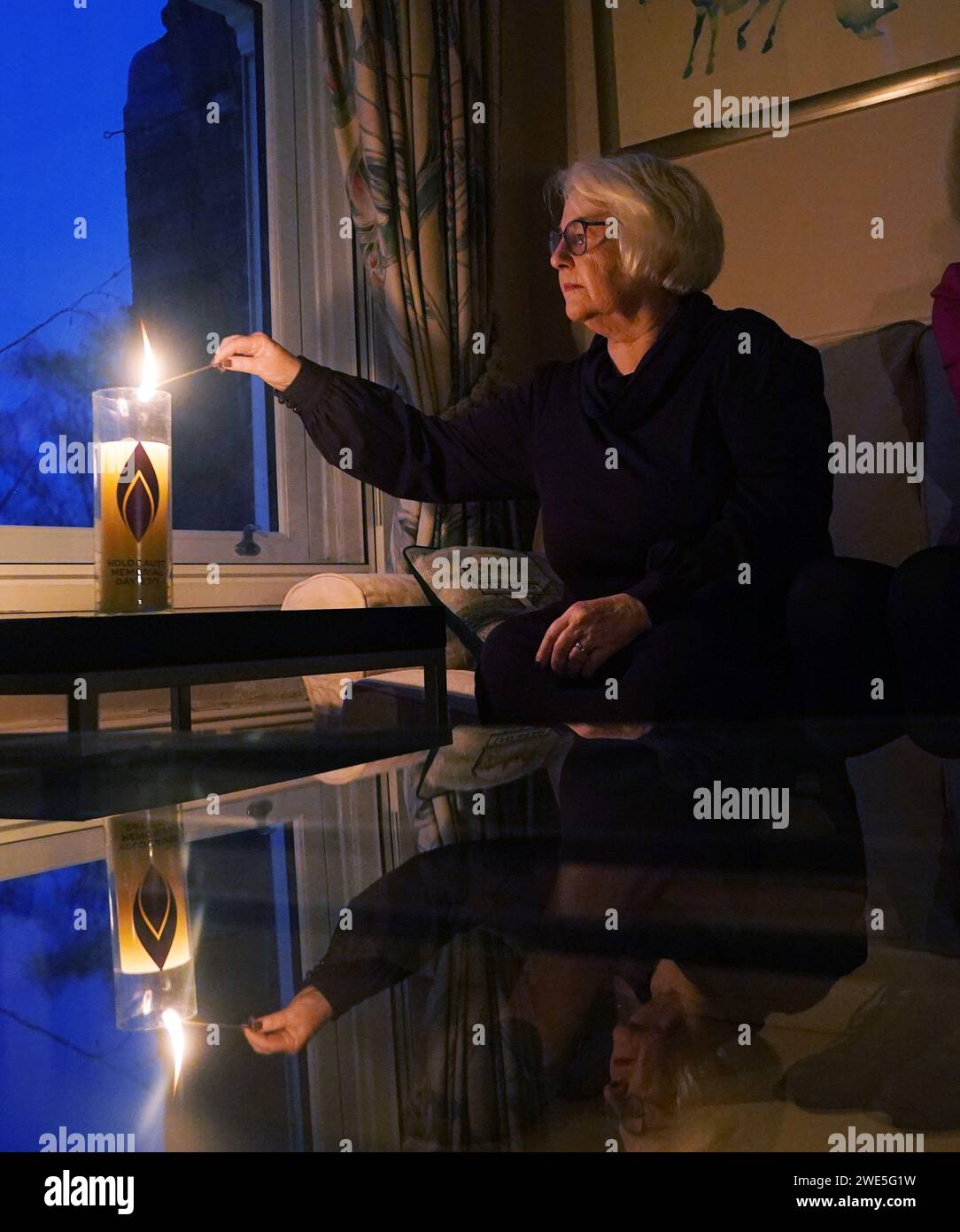 Holocaust survivor Joan Salter lights a memorial candle at her home in ...
