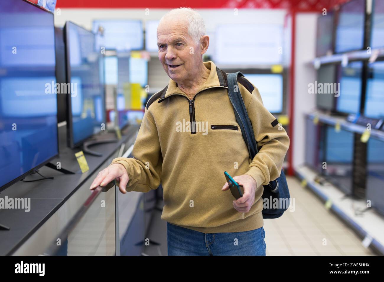 Elderly grayhaired man pensioner looking counter with modern digital ...