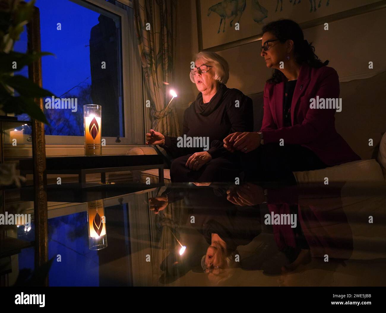 Holocaust survivor Joan Salter (left) lights a memorial candle at her ...