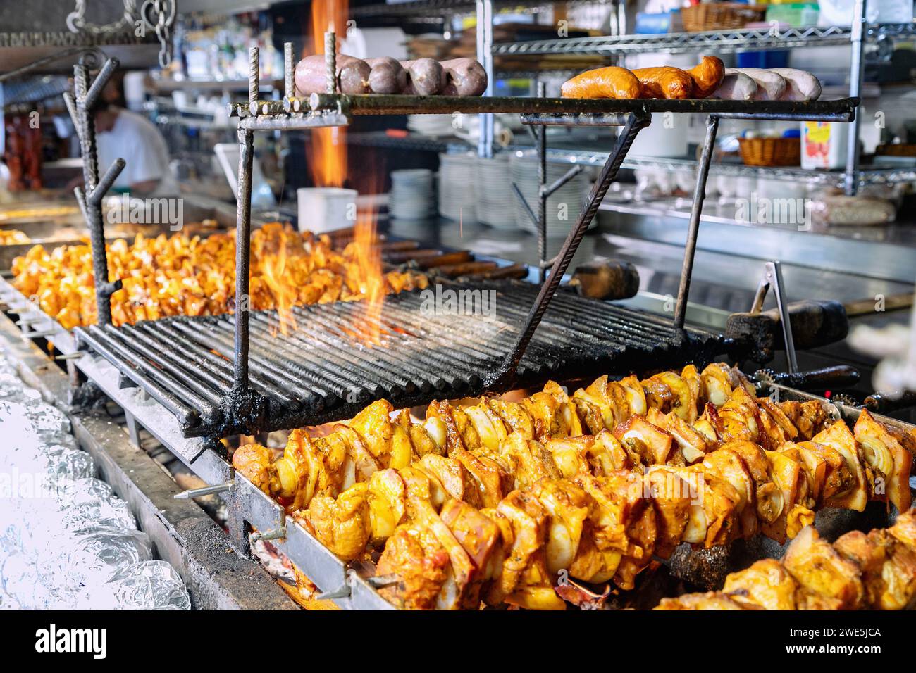 Shish kebab skewers and grilled Polish sausages at a street grill in ...