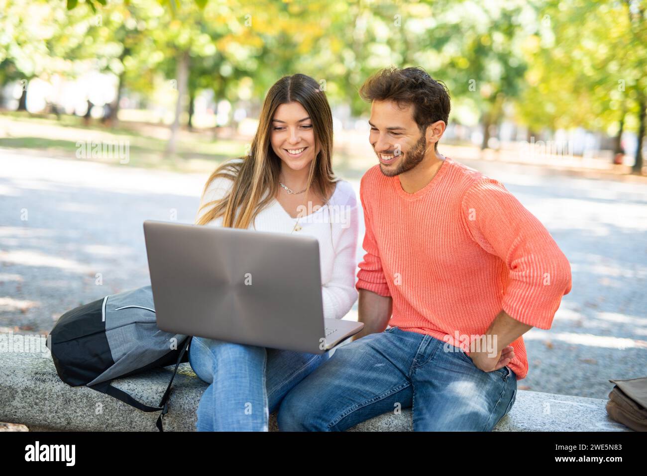 College students using a laptop computer in a park, young people and ...