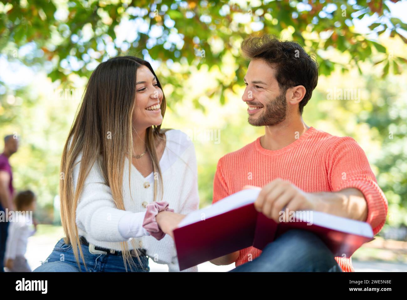 Two students studying together sitting on a bench outdoor Stock Photo ...