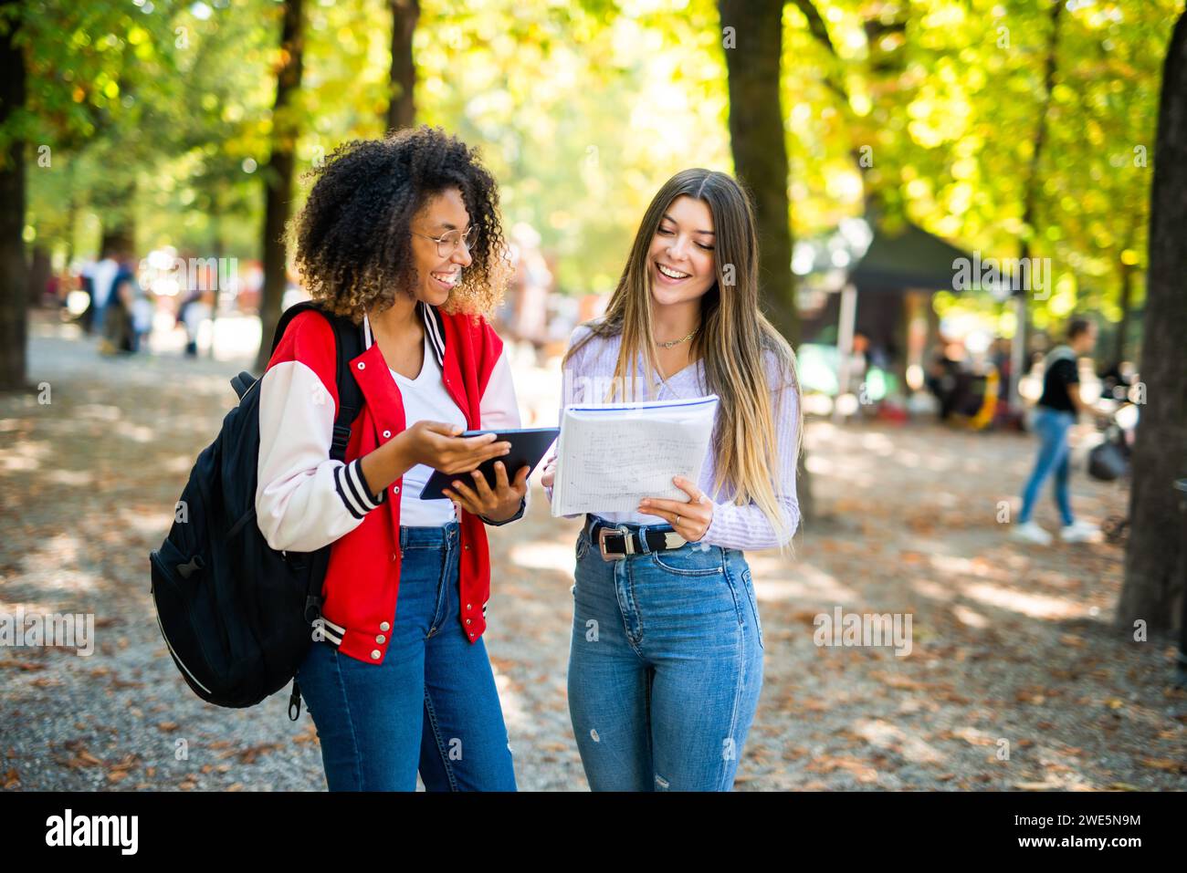 Female college students studying together in a park near their ...