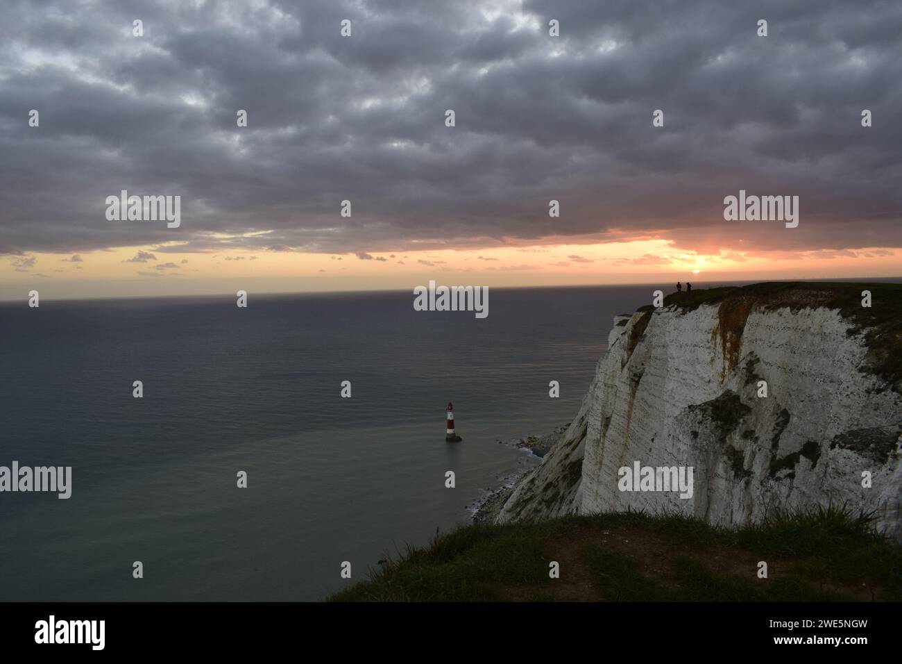 Beachy head Lighthouse in the sea with beautiful red sunset for a ...