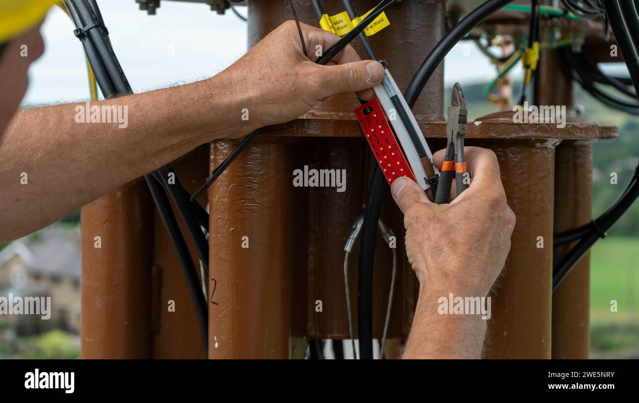 Person working on a mast site at height Stock Photo - Alamy