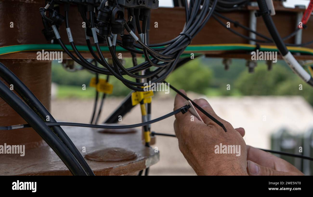 Person working on a mast site at height Stock Photo - Alamy