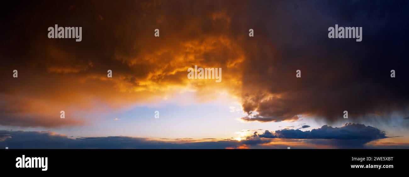 Dramatic sunset sky with dark rainy clouds illuminated with sun ...
