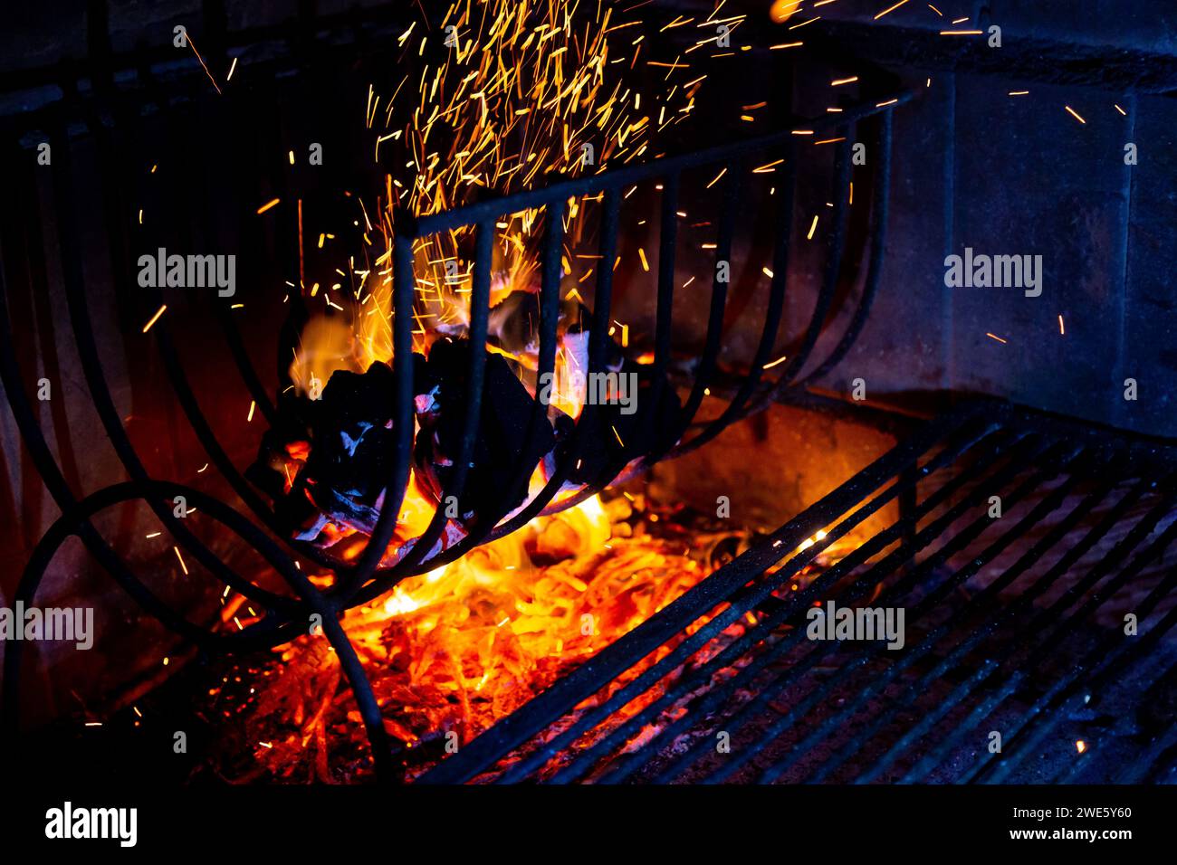 Lighting the fire for the barbecue. Burnt black charcoal igniting and ...