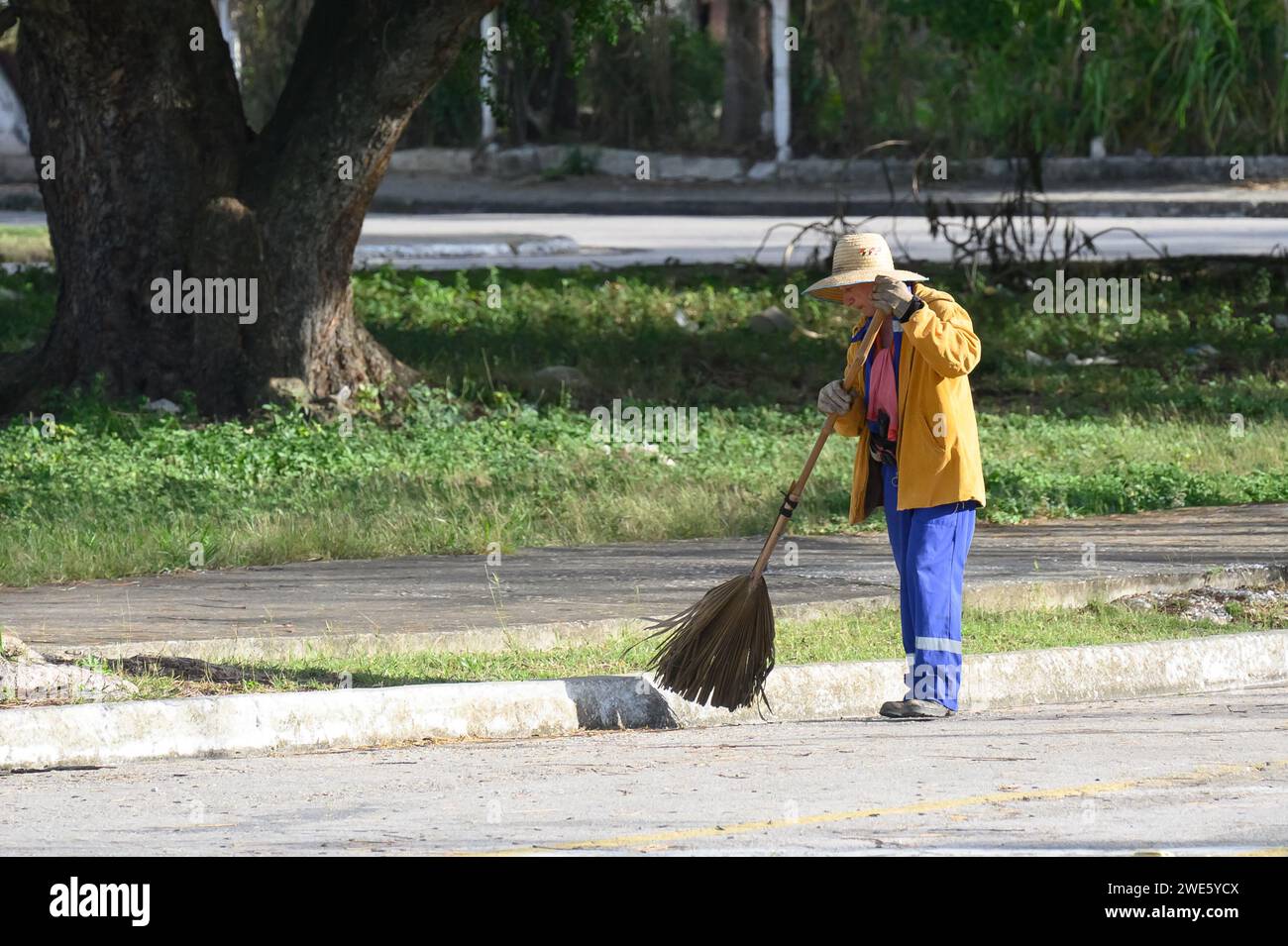 A senior person works as a street sweeper Stock Photo - Alamy