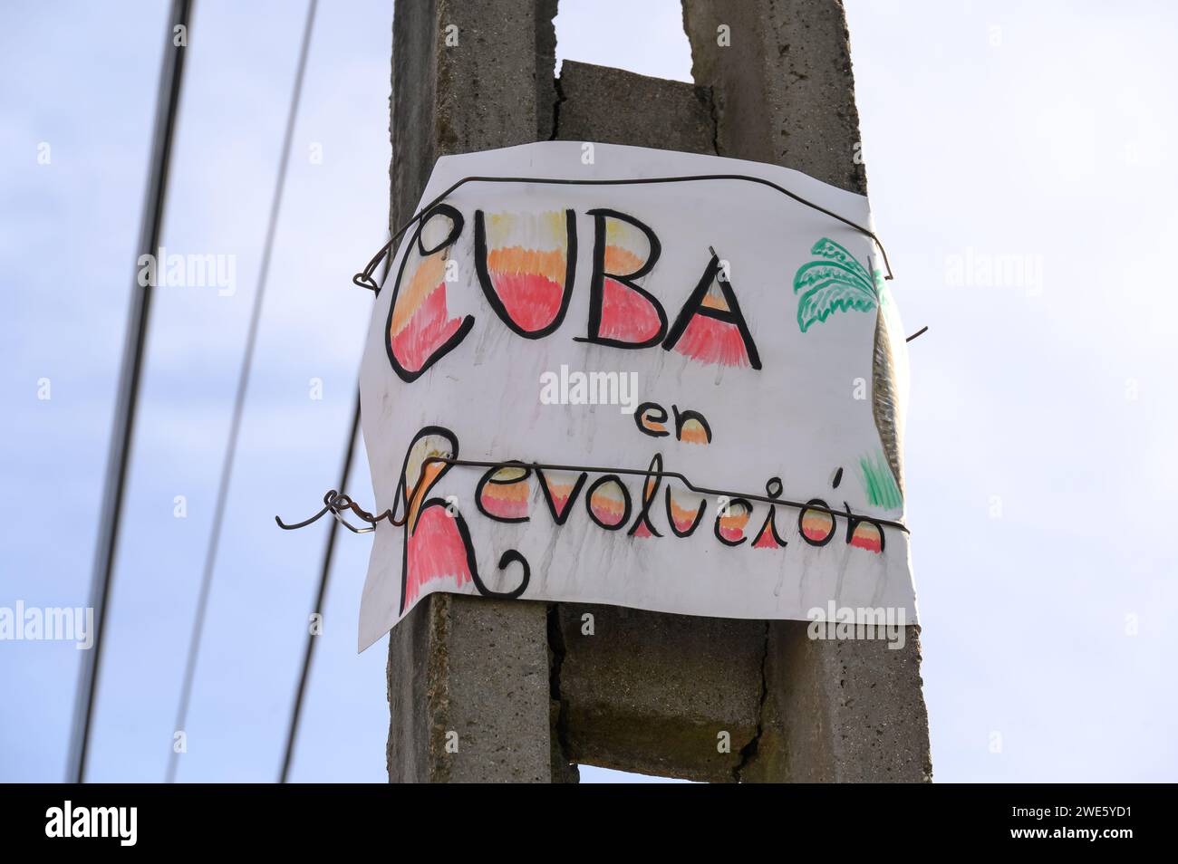Handwritten propaganda sign on an electricity pole. It reads Cuba In ...