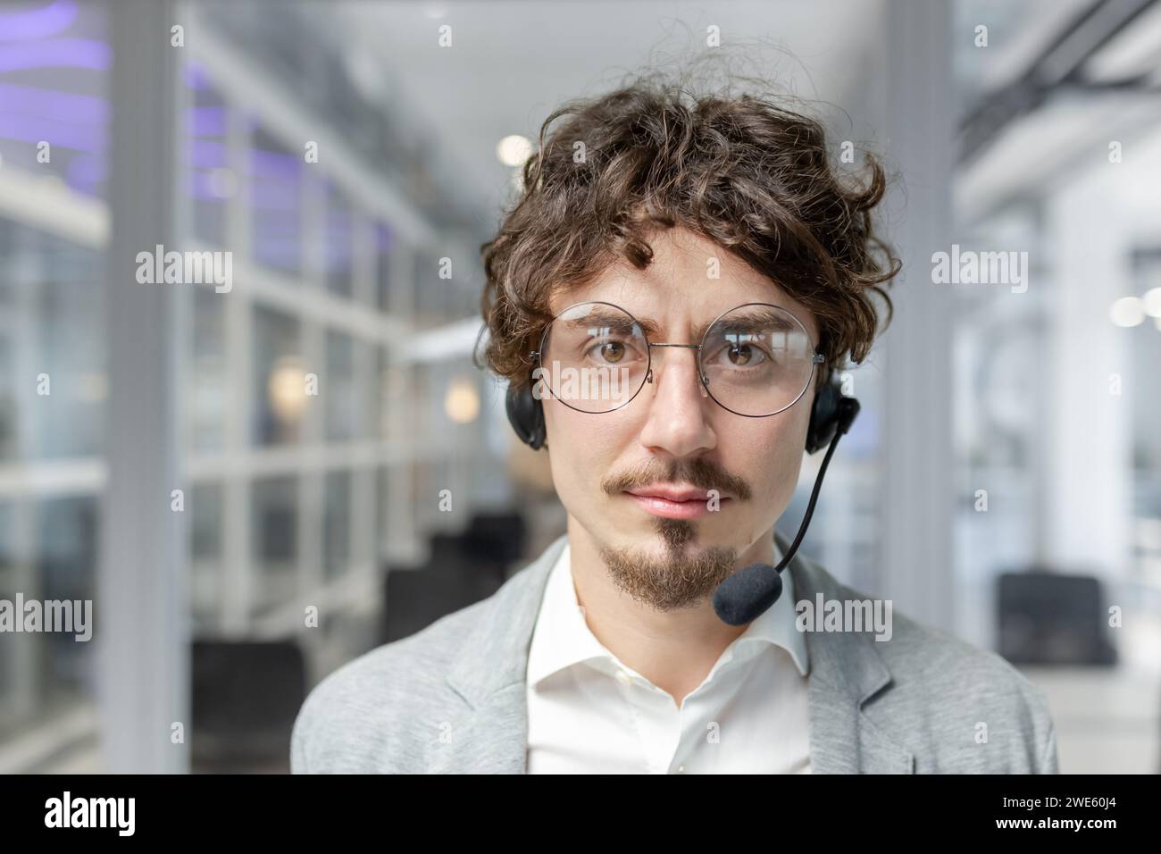 Adult male office worker with a headset appears concentrated and ...