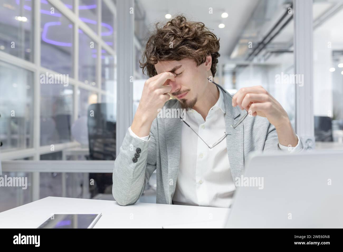 Exhausted adult businessman showing signs of fatigue and stress while ...