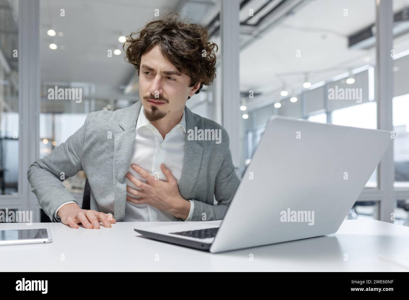 Professional young adult male office worker looking uneasy or stressed ...