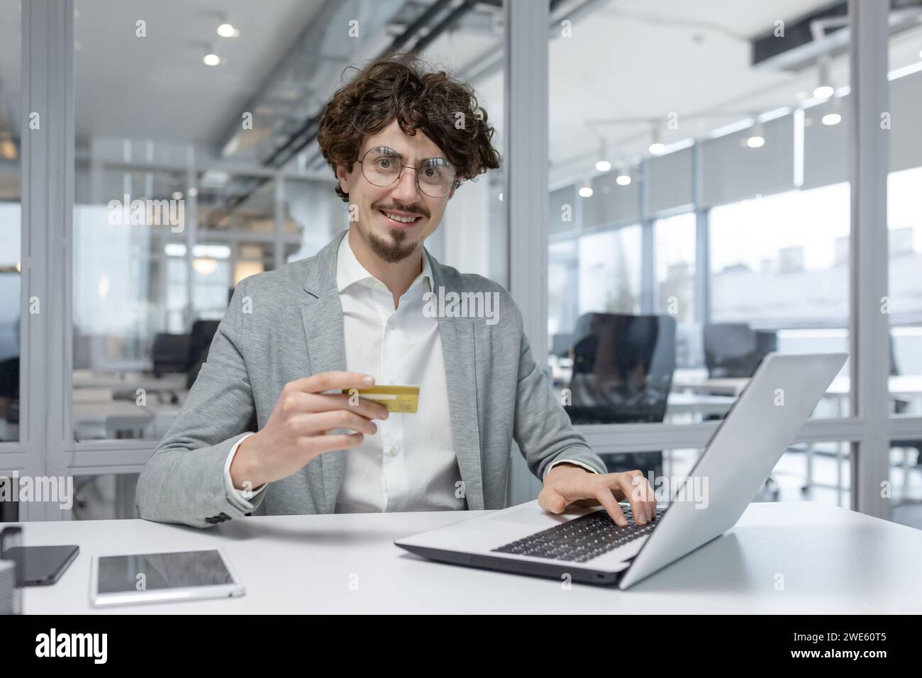 Confident male office worker engages in online transactions, showing ...