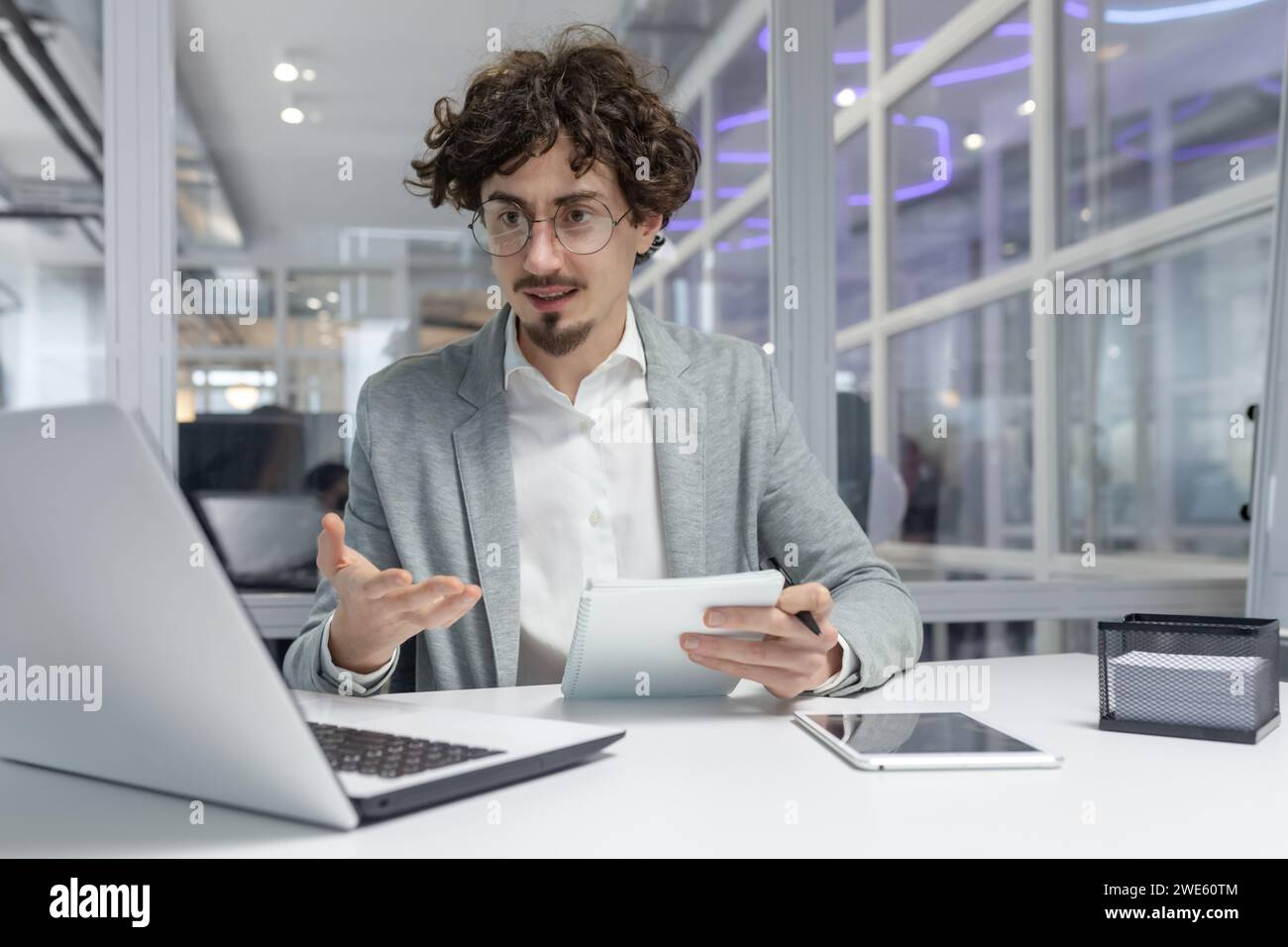 Professional young adult businessman concentrating at his workplace ...