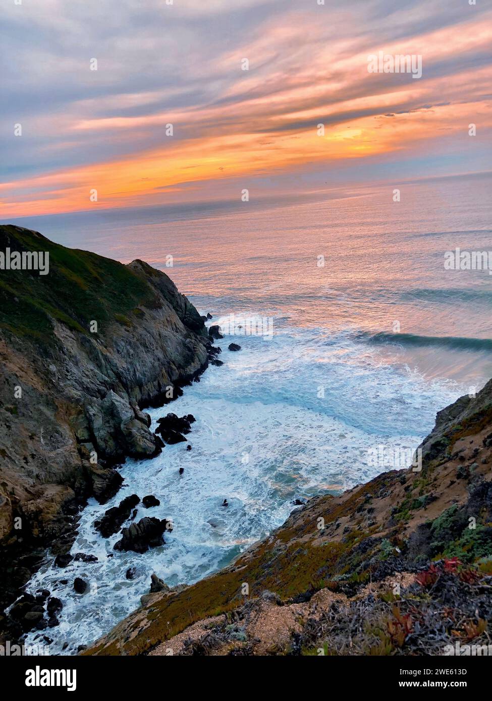 An awe-inspiring sunset casts a warm glow over the tranquil ocean view ...