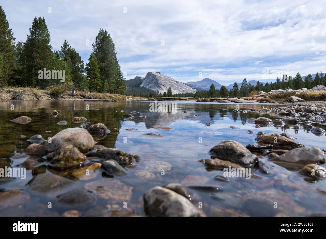 A serene landscape featuring a majestic mountain towering over a ...