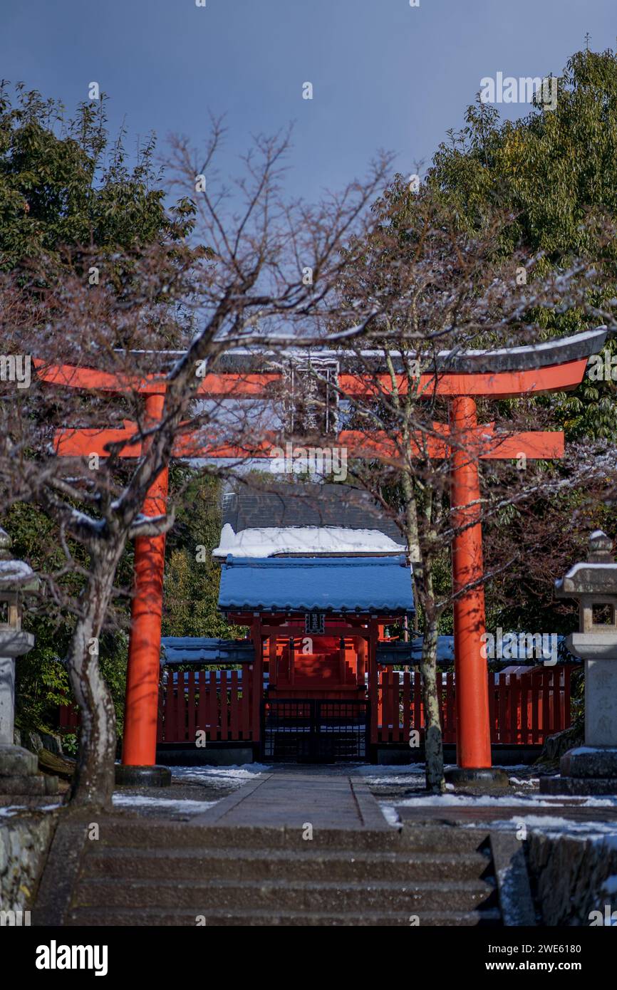 Orange torii gate with red pillars, surrounded by snow-covered ground ...