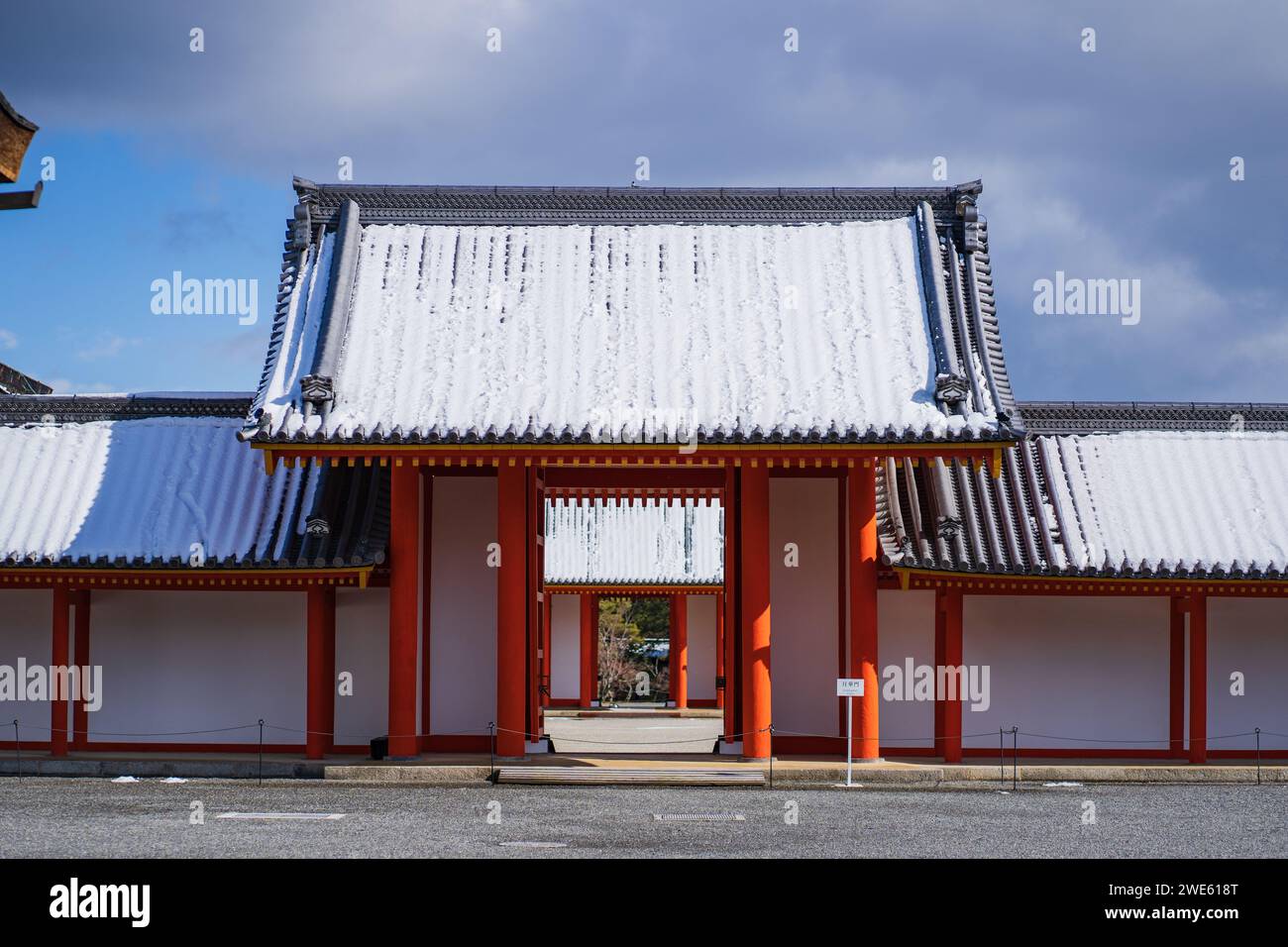 A colorful Asian building with distinct white and red roofs, featuring ...