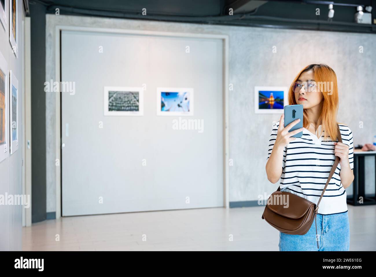 Visitor woman standing takes picture art gallery collection in front ...