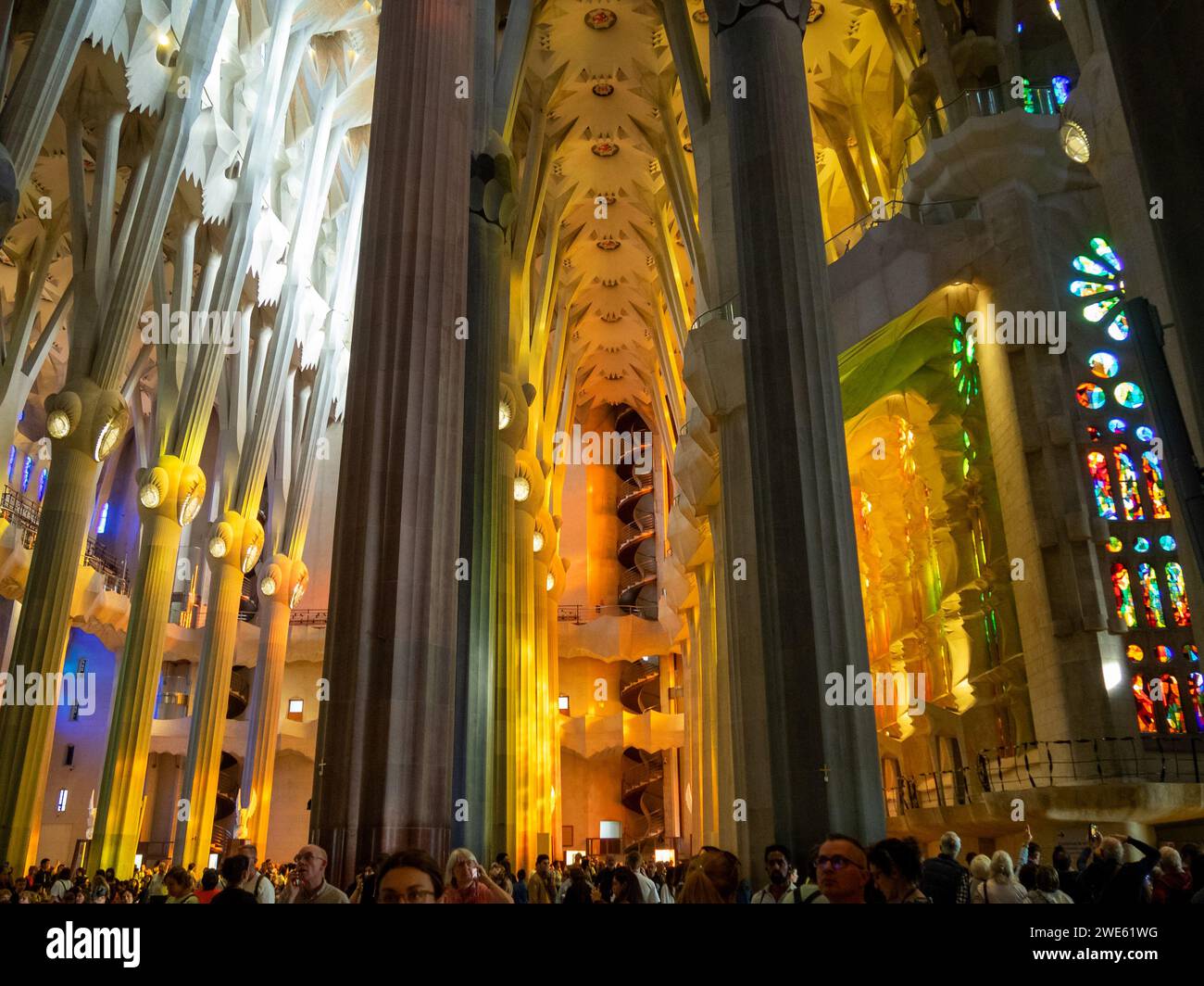 Tourists inside Sagrada Familia Basilica admiring the colored light ...