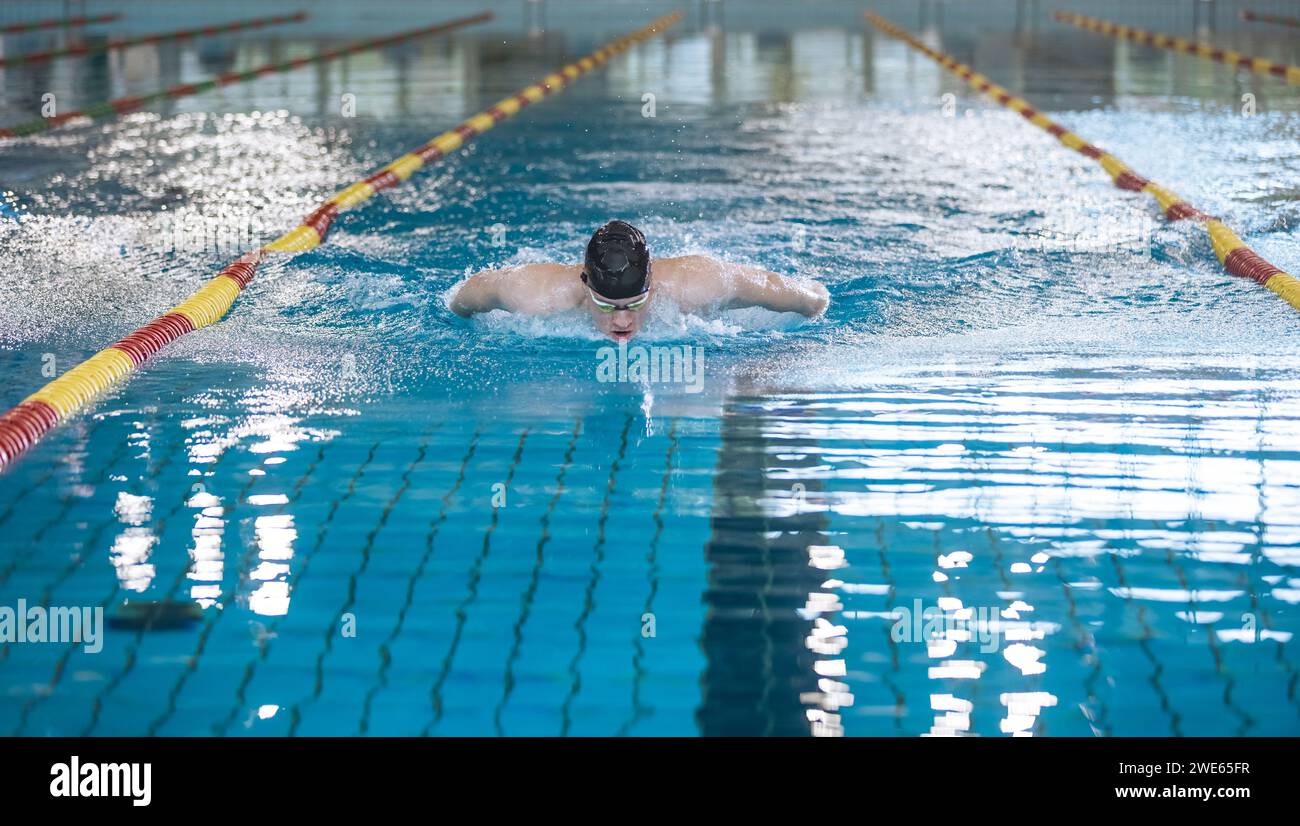 Male professional athlete swimming in butterfly style, with both arms ...