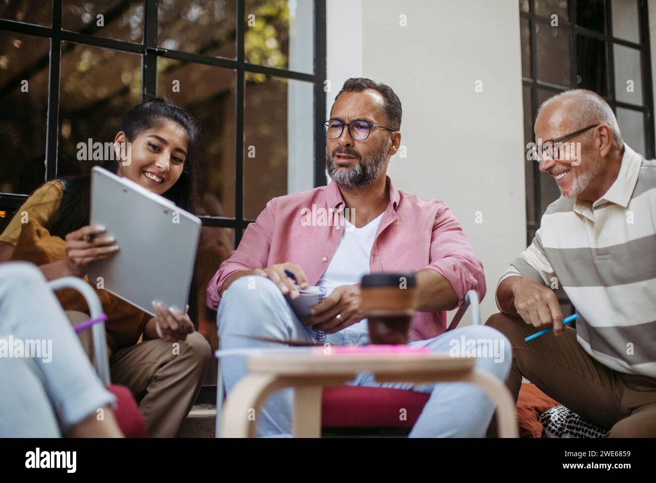 Group of committed people having meeting in front of community building ...