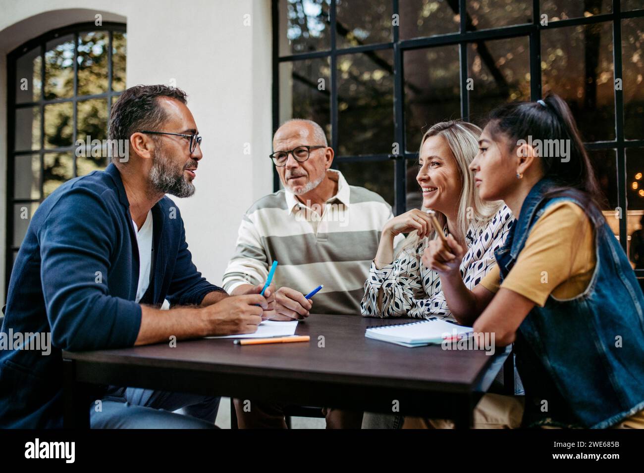Group of committed people having meeting in front of community building ...
