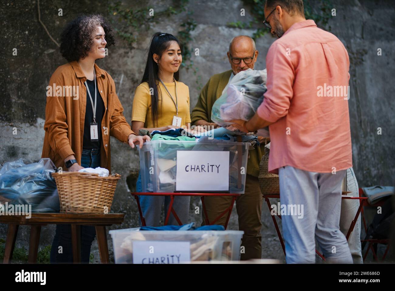 People sorting donated used clothes for charity Stock Photo - Alamy