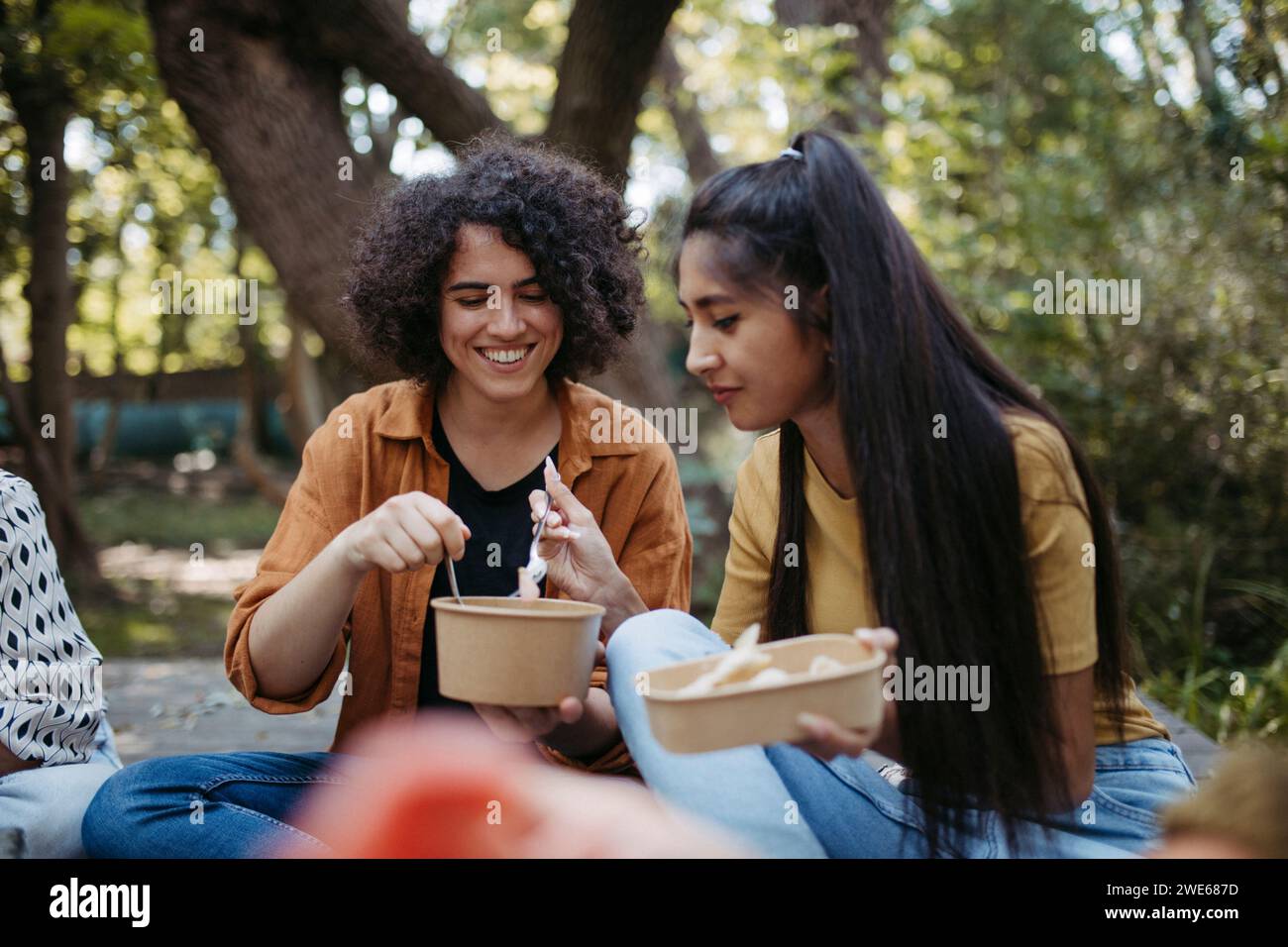 Volunteers at community project eating together in community garden ...