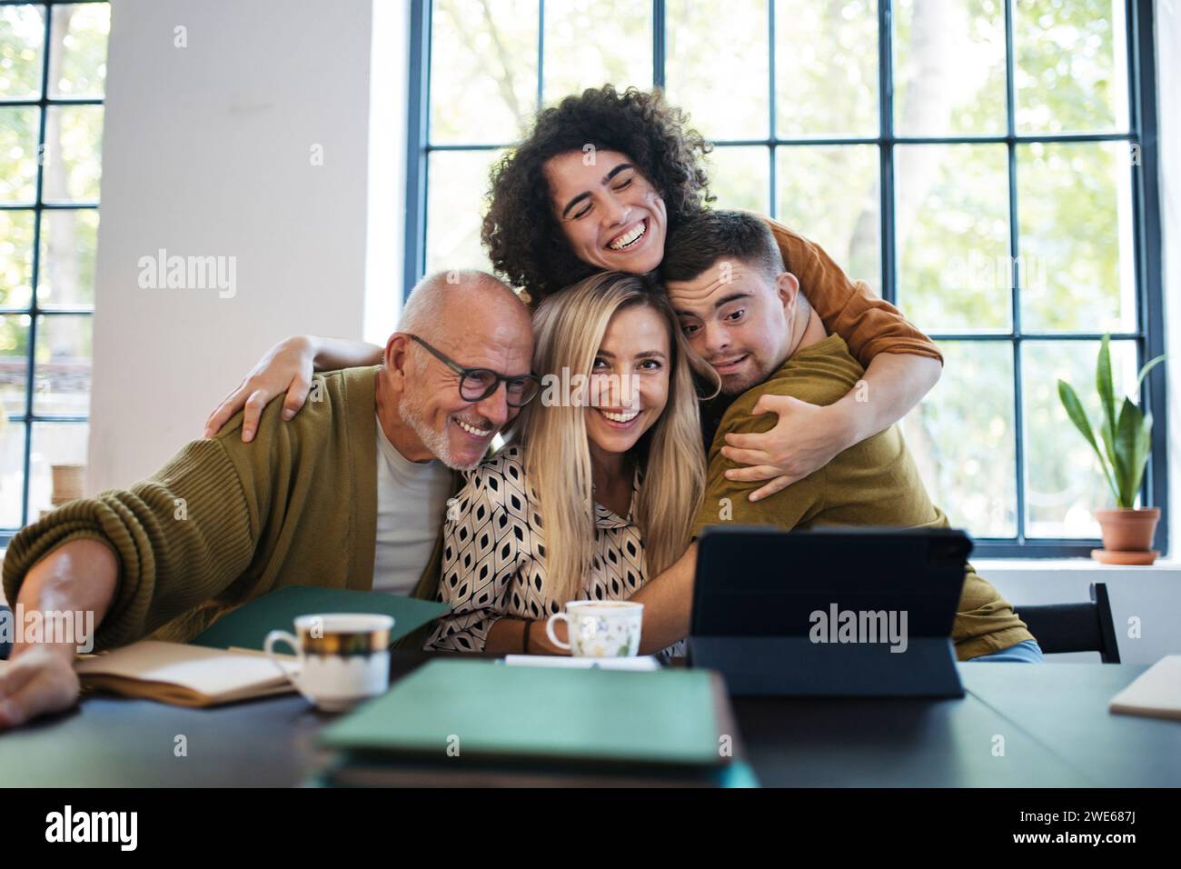 Person with disability working with colleagues in inclusive community ...