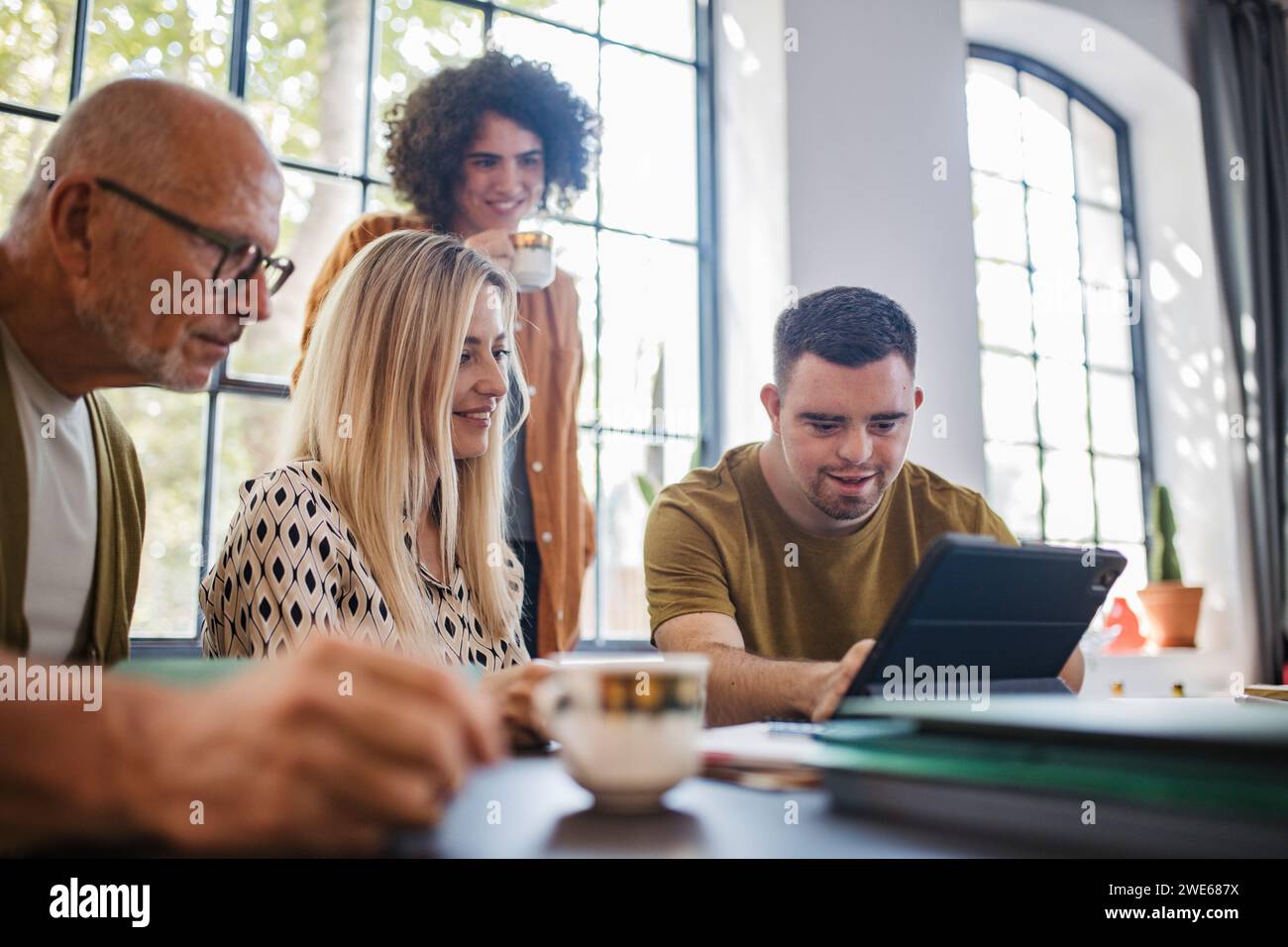 Person with disability working with colleagues in inclusive community ...