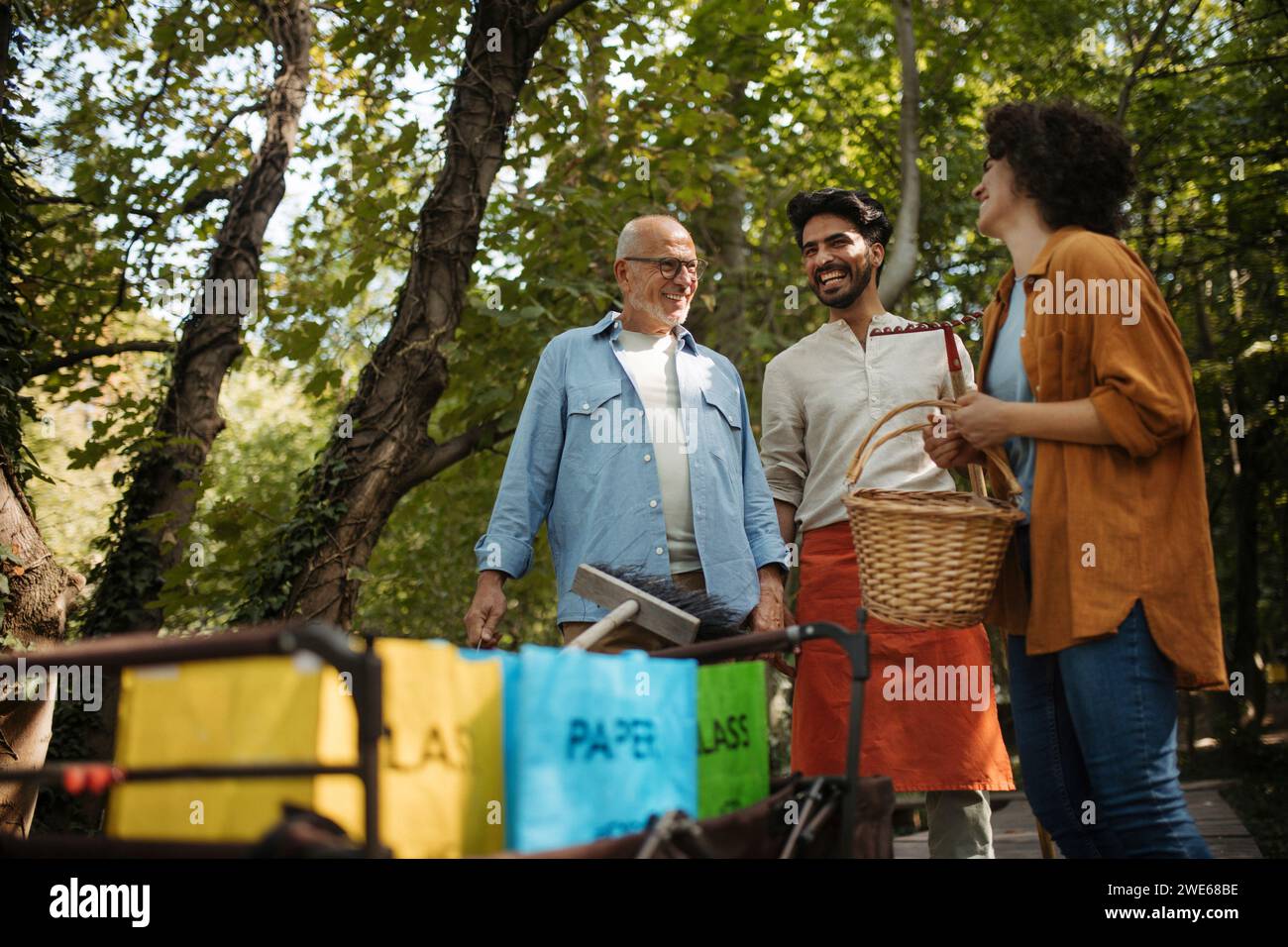 Group of volunteers taking part in community cleanup at park with waste ...