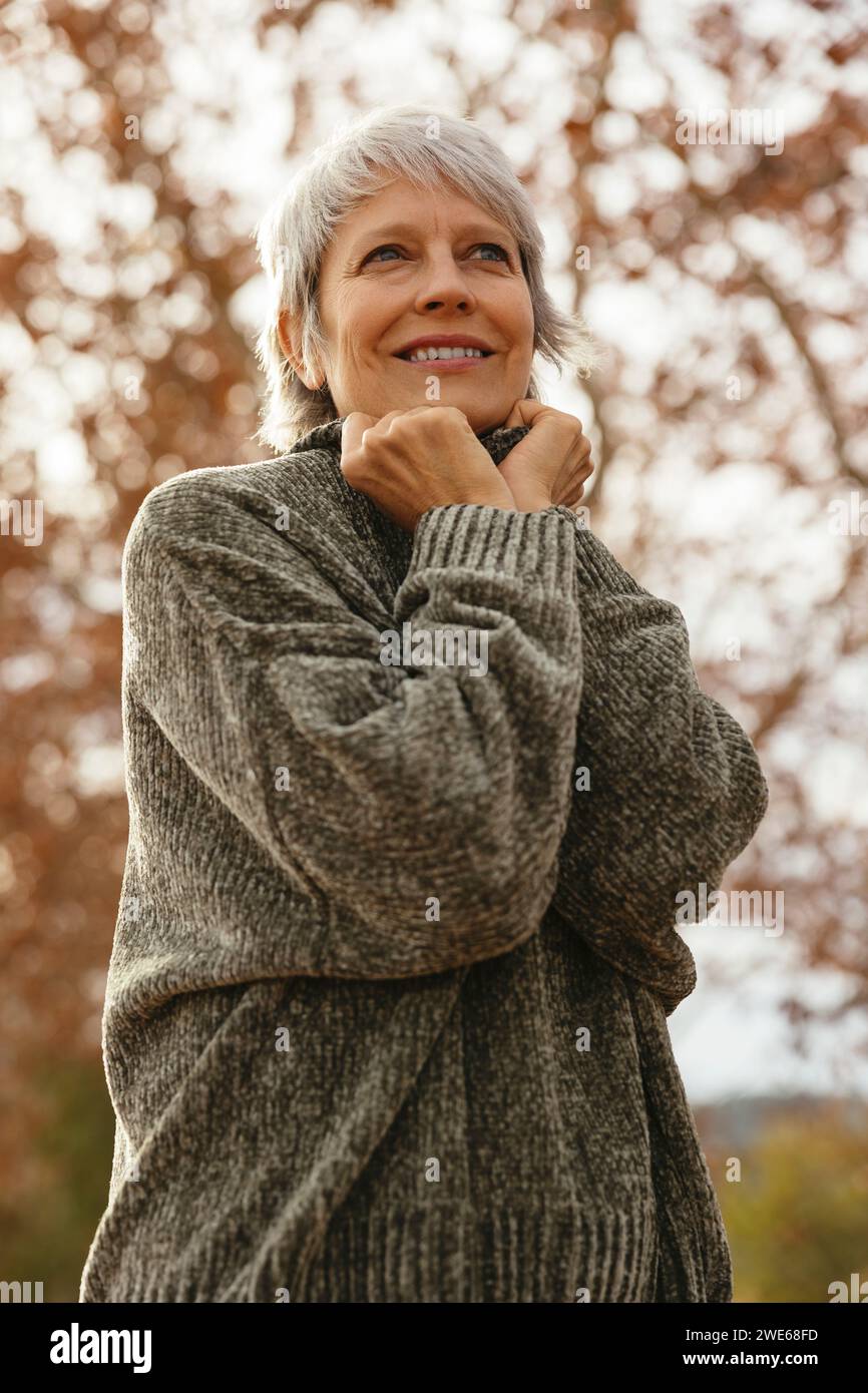 Happy mature woman wearing gray sweater Stock Photo - Alamy