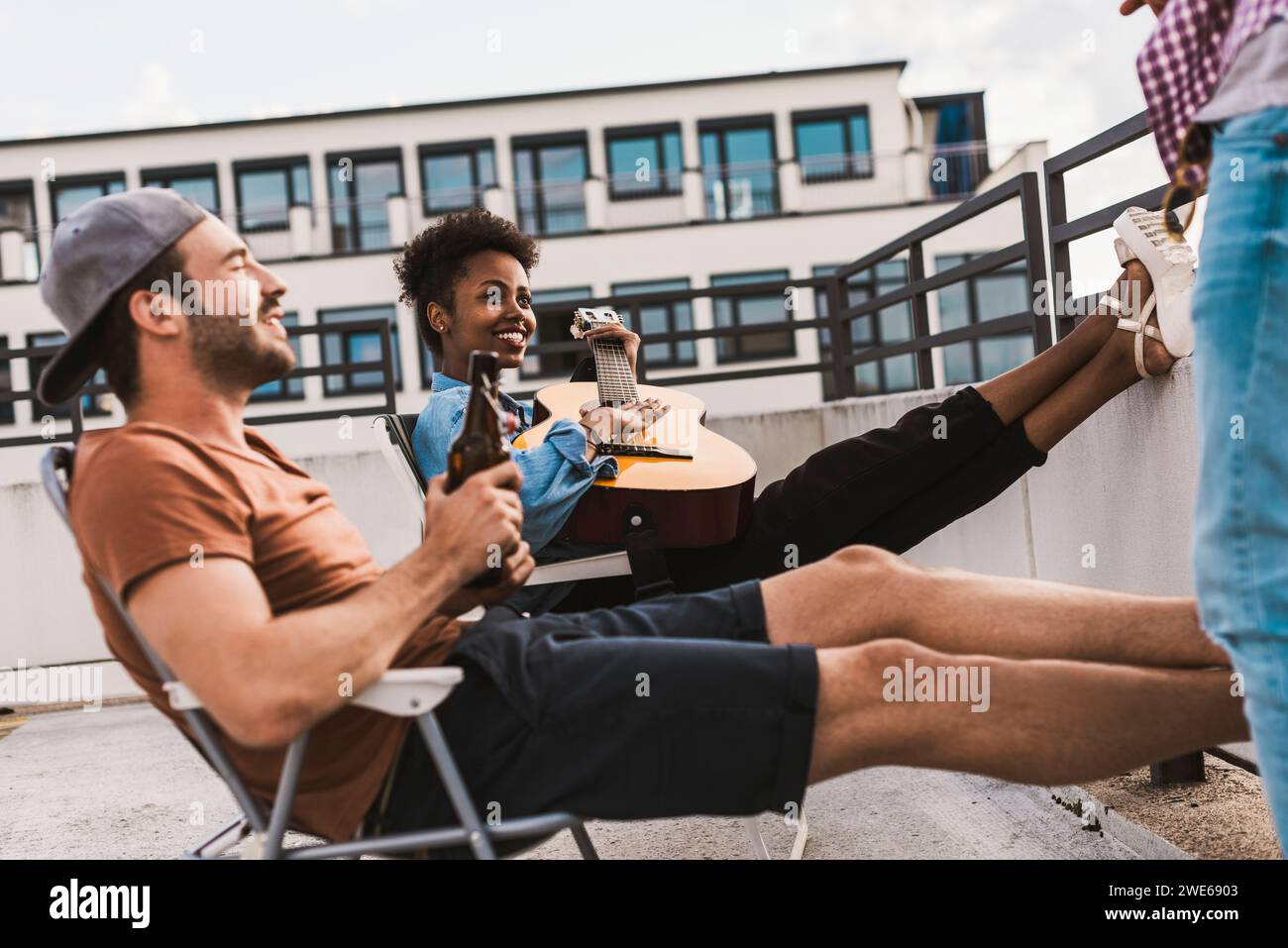Smiling friends having party on rooftop Stock Photo - Alamy