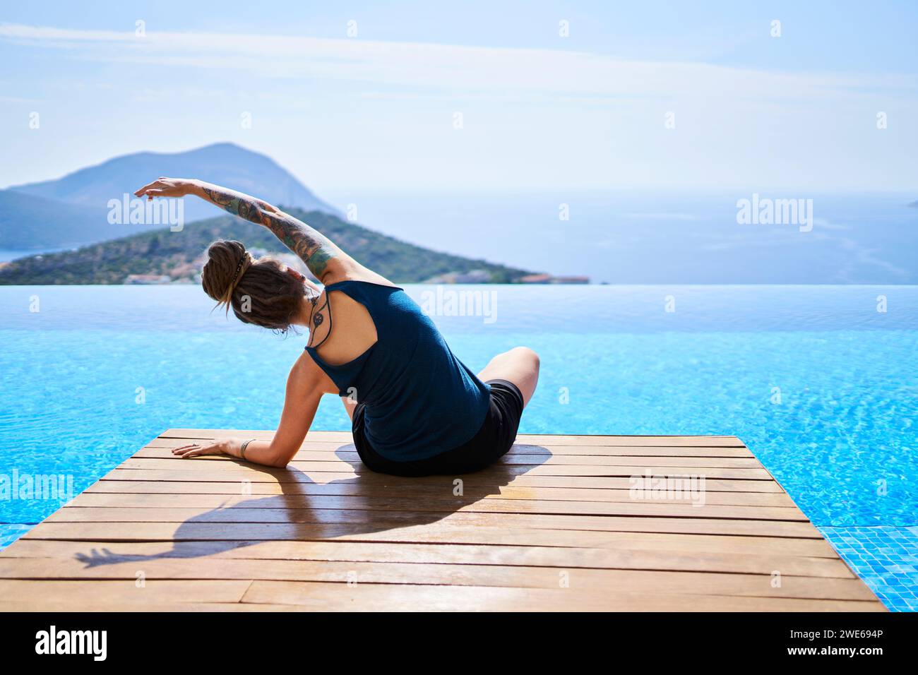 Woman doing stretching exercise near swimming pool Stock Photo - Alamy