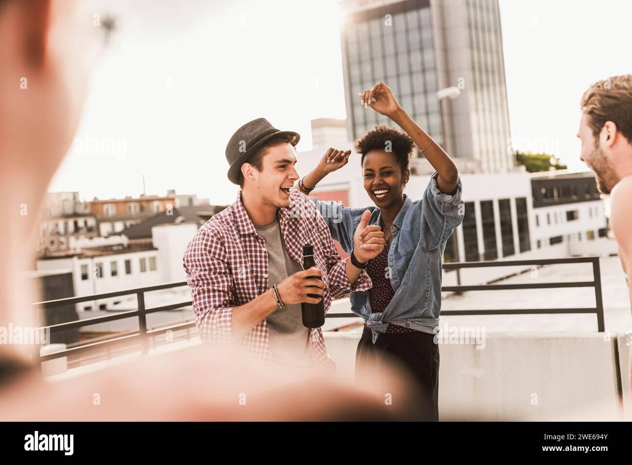 Smiling friends dancing and enjoying on rooftop Stock Photo - Alamy